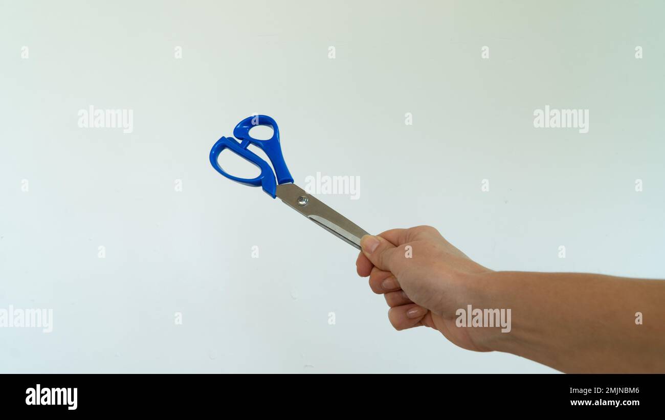 The hand passes the scissors holding the blade, proper feeding of ...