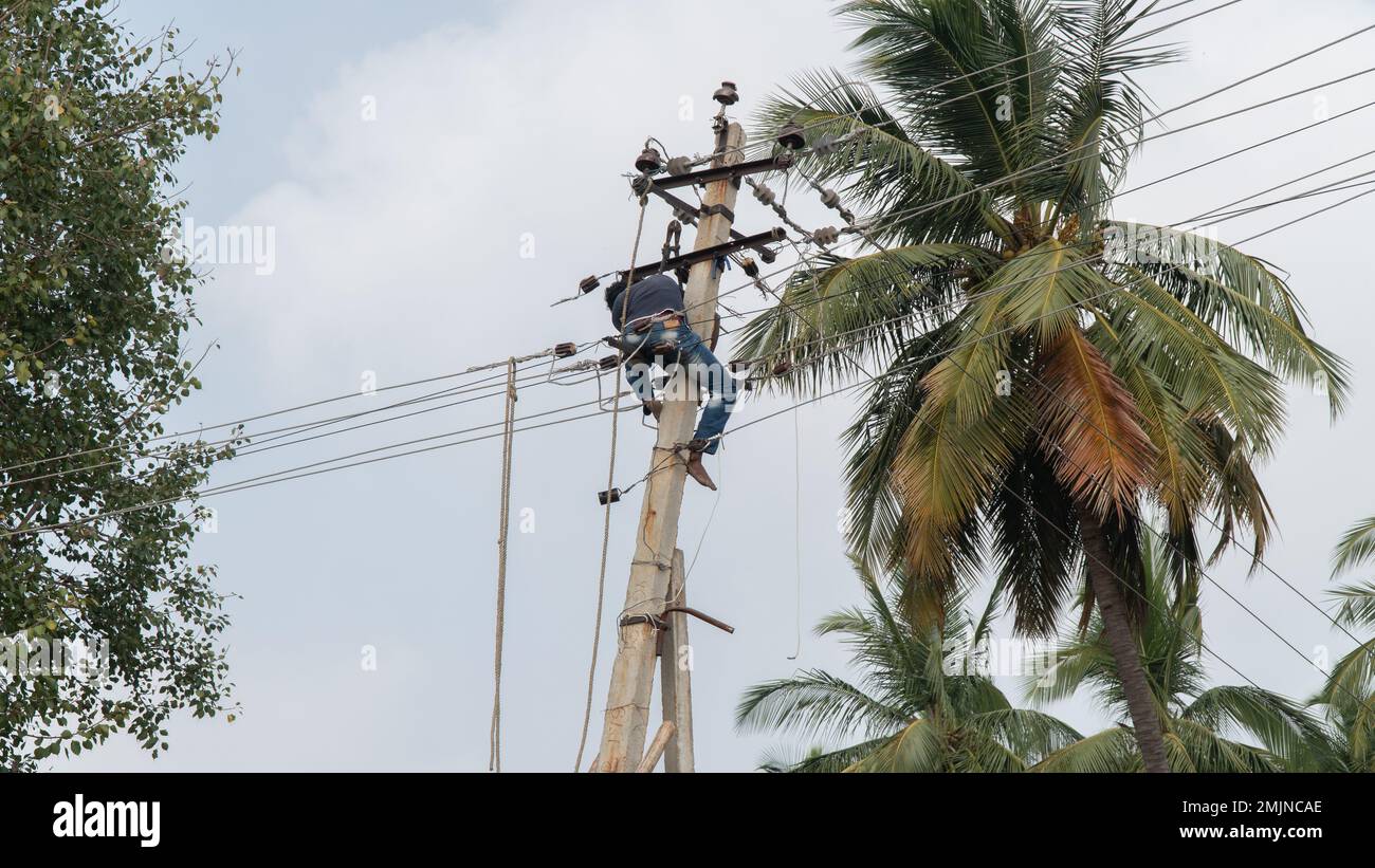 An electrician on a pole fixing electrical wires Stock Photo - Alamy
