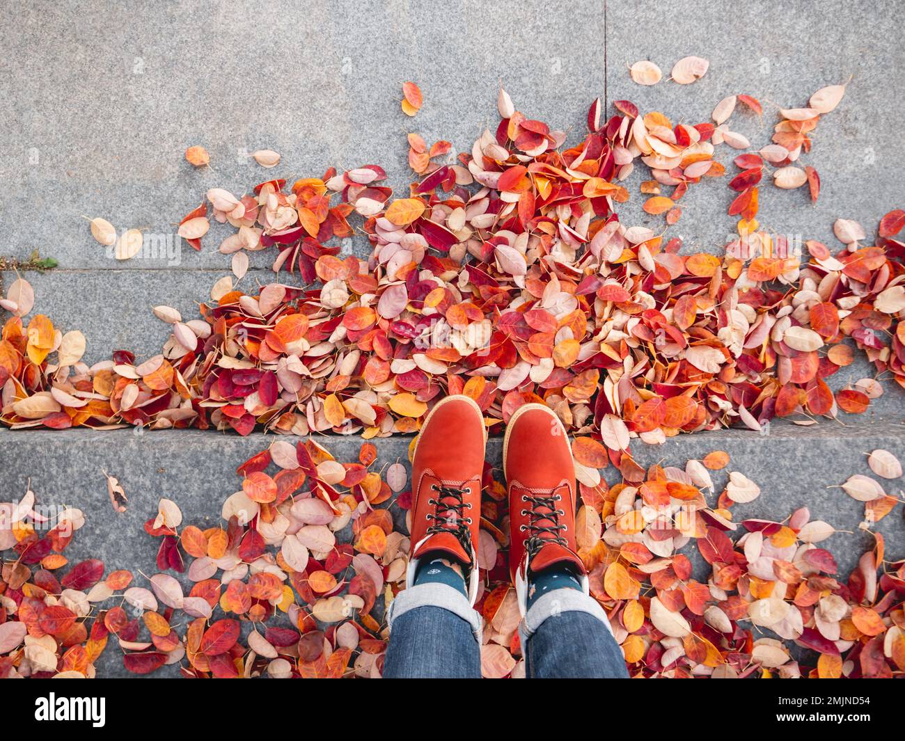 Top view on feet in red leather shoes. Woman is standing on stone ...