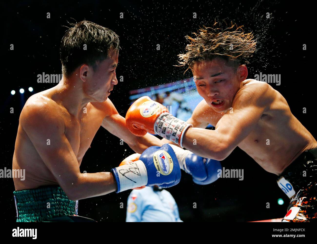 Japanese champion Hiroto Kyoguchi, right, gets a punch from Thai ...