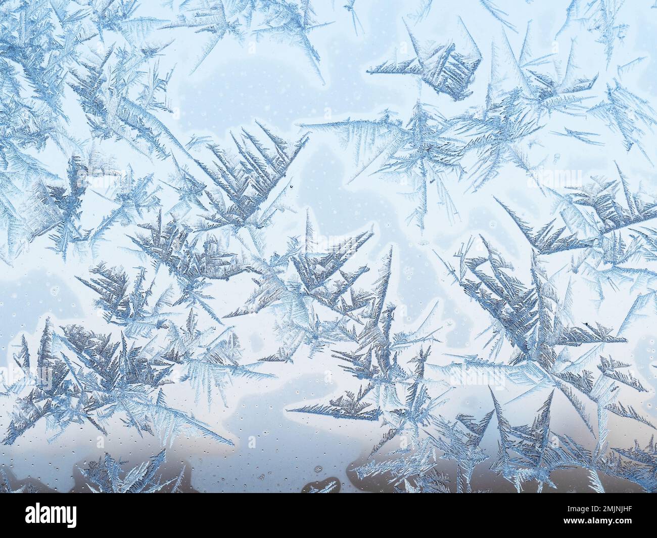 natural blue frost pattern on window glass closeup on cold winter day ...