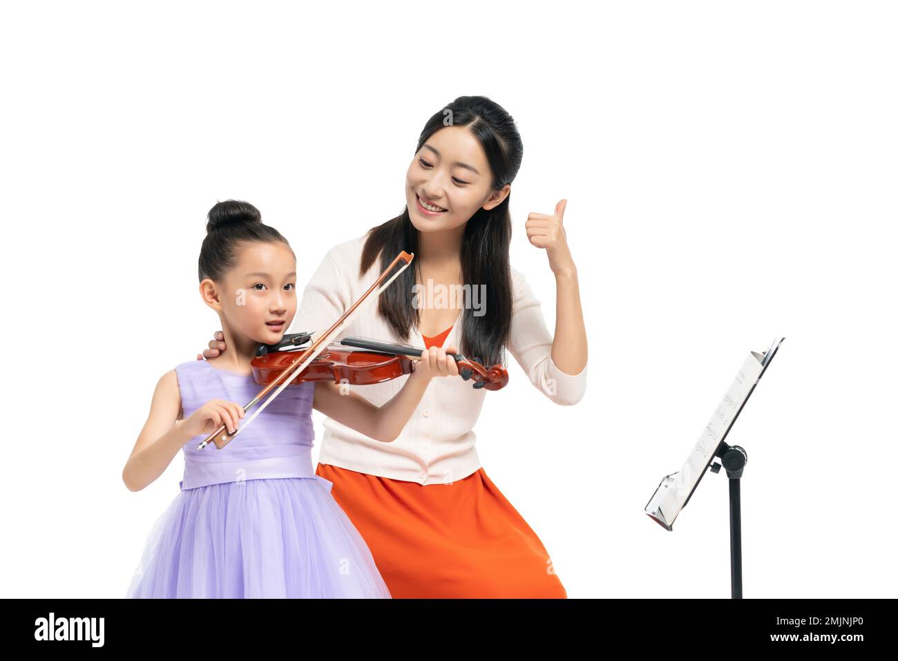 The female teacher guide girl playing Musical Instruments Stock Photo ...