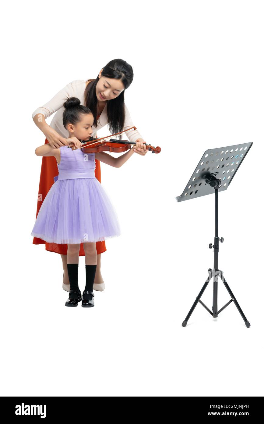 The female teacher guide girl playing Musical Instruments Stock Photo ...
