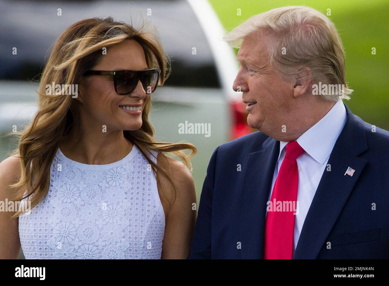 President Donald Trump, accompanied by first lady Melania Trump, smiles ...