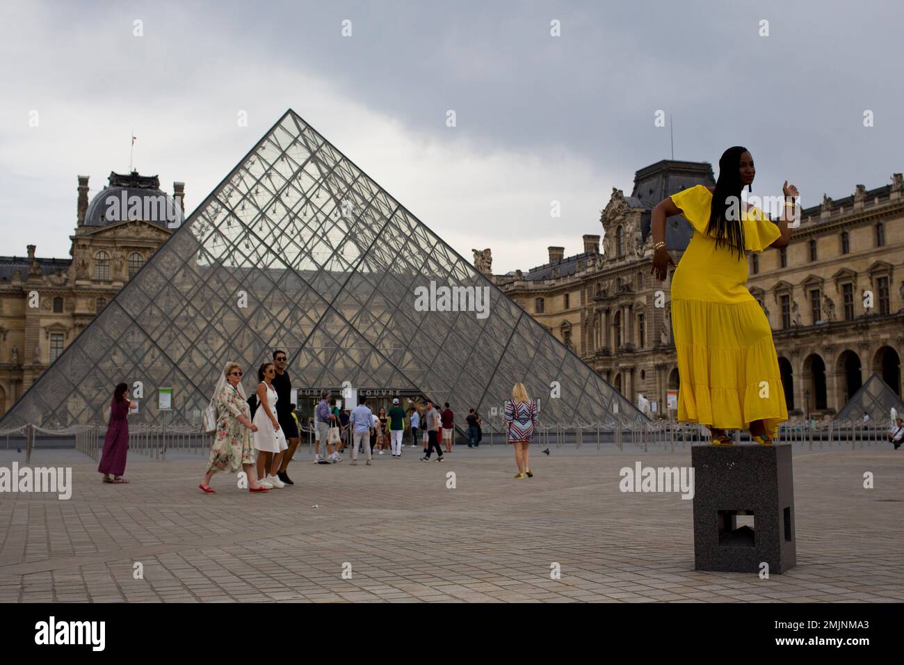 A woman poses for a photo in front of the pyramid of the Louvre museum ...