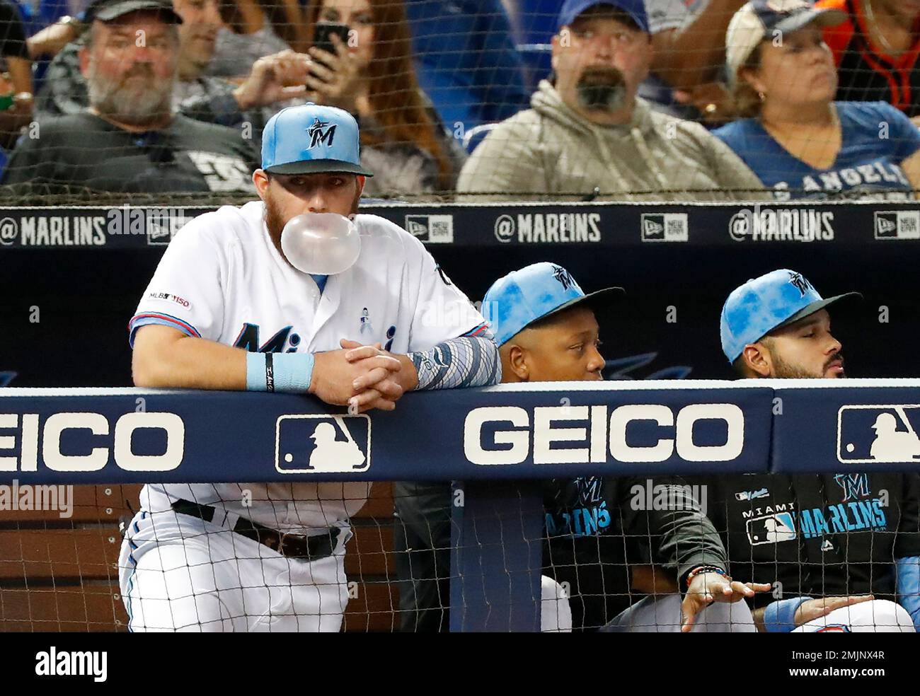 Miami Marlins' Austin Dean blows a bubble as he watches a baseball game ...