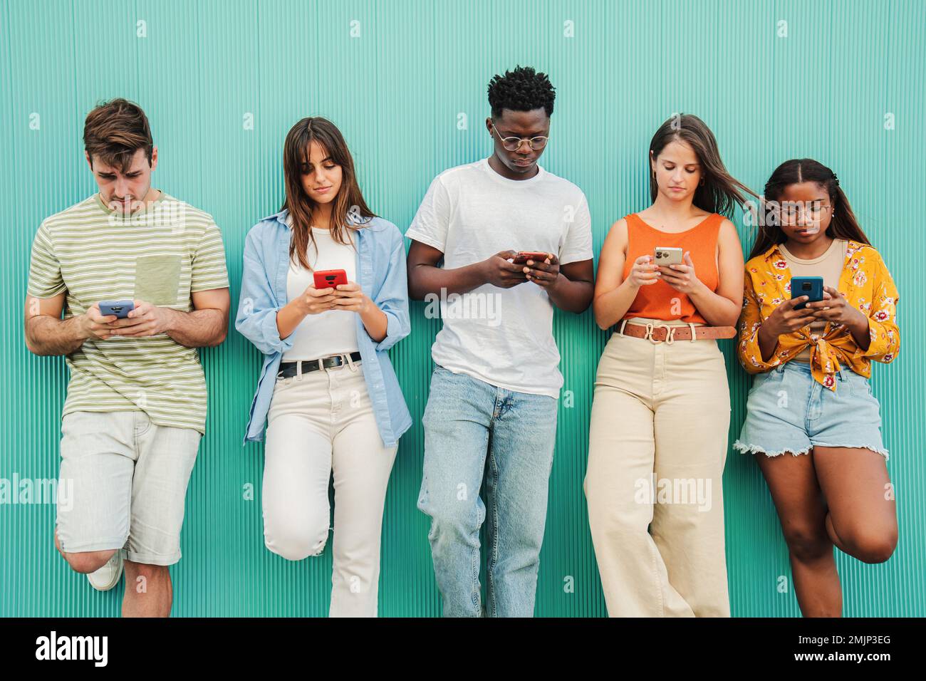 Group of multiethnic teenagers addicted to use the smartphone on blue ...