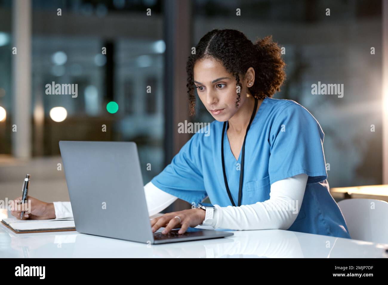 Laptop, healthcare and doctor writing in notebook for medical research, planning and schedule in ...