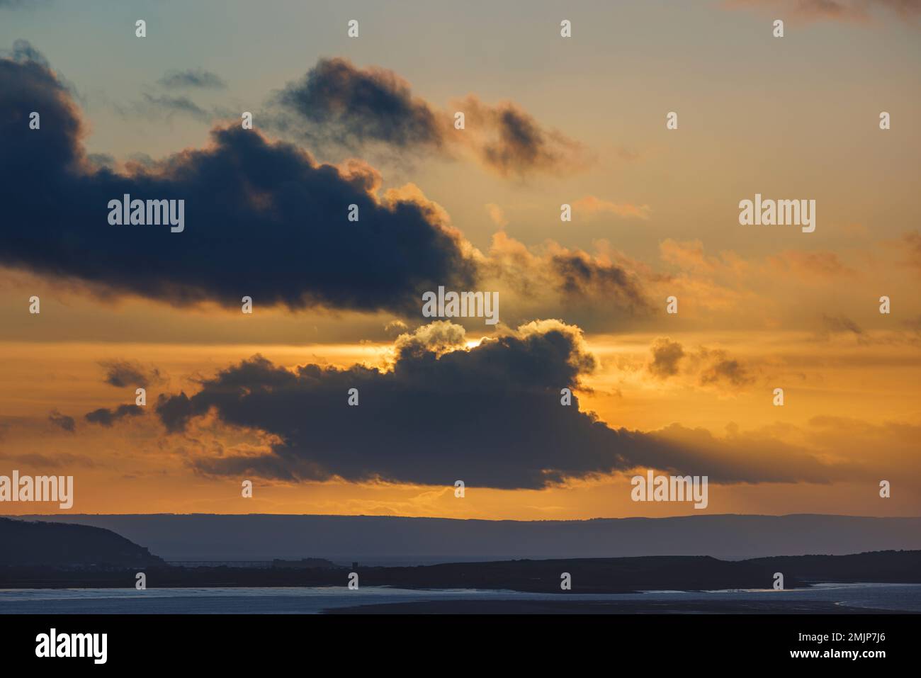 The setting sun lighting up the cloud cover Stock Photo - Alamy
