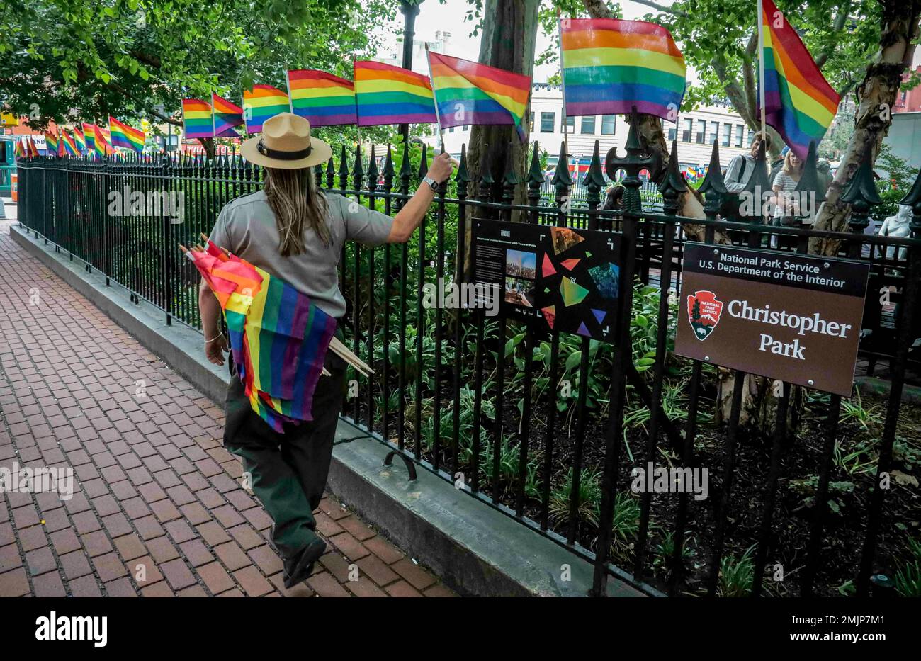 A National Park Service ranger place rainbow flags, representing LBGTQ ...