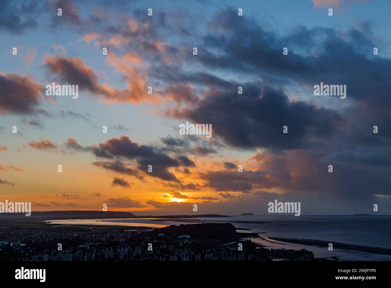 The setting sun lighting up the cloud cover Stock Photo - Alamy