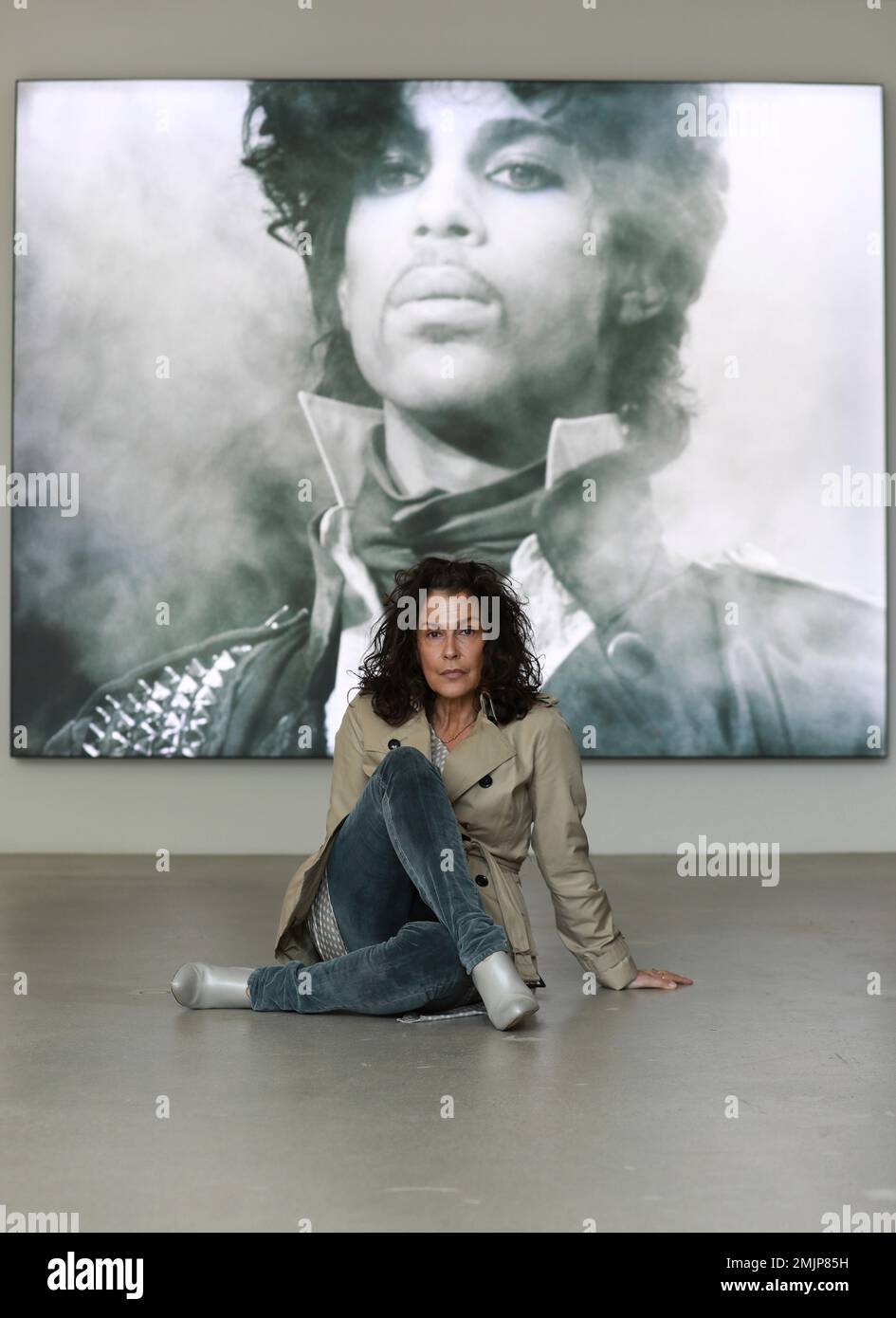 Susannah Melvoin poses next to a photo of Prince at Warner Music Group ...