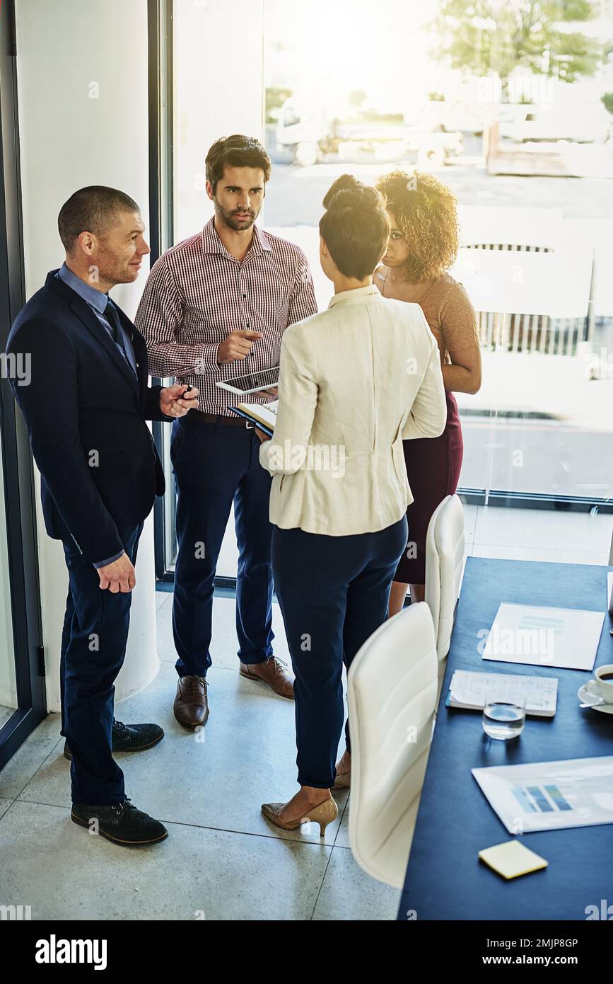 She has their full attention. a group of colleagues meeting in the ...