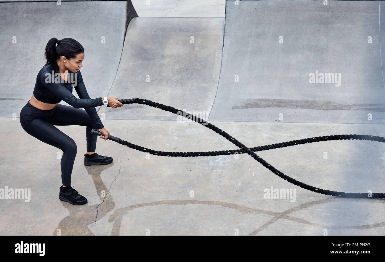 Fitness, battle ropes and strong with a black woman athlete outdoor for ...