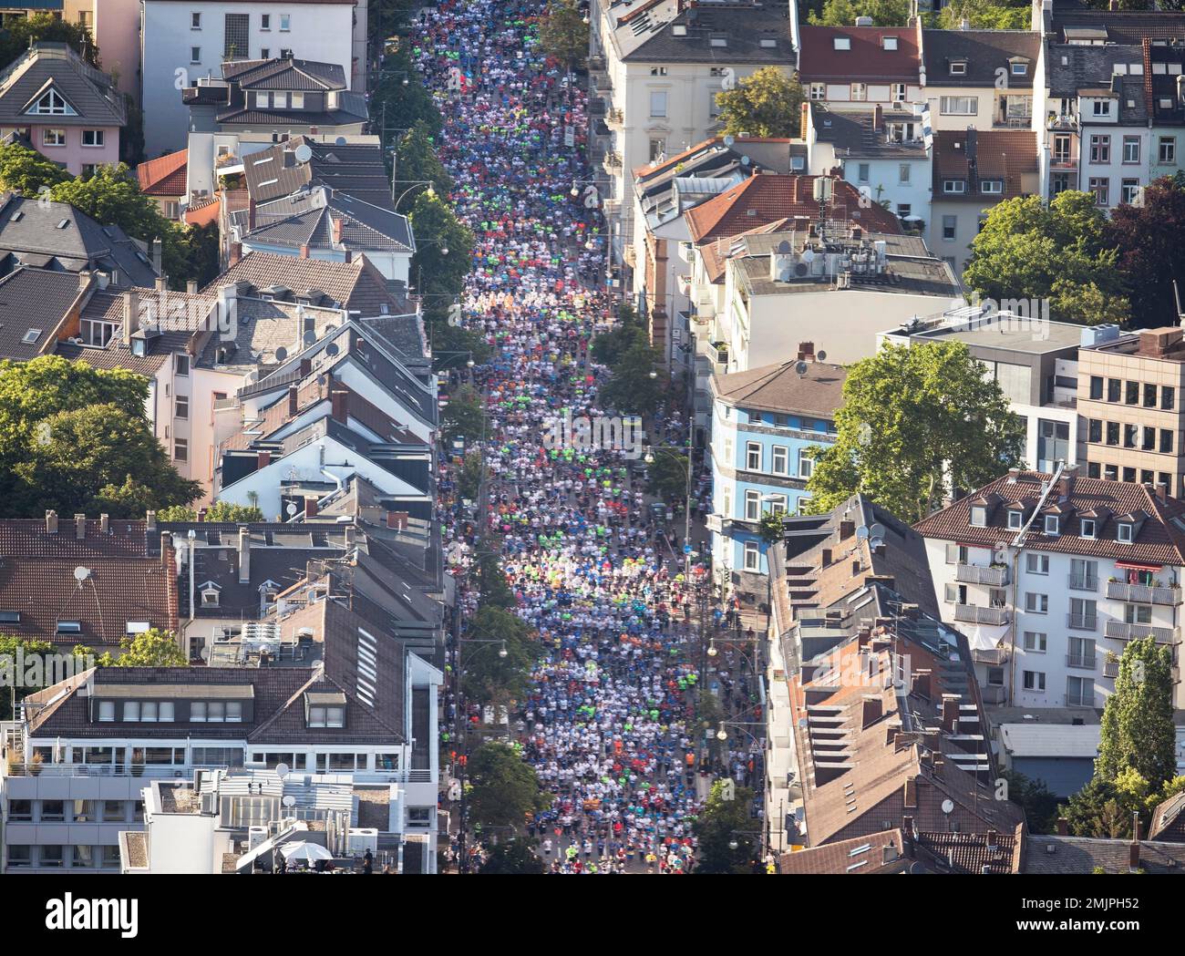 Runners pass houses during the J.P. Morgan Corporate Challenge company ...