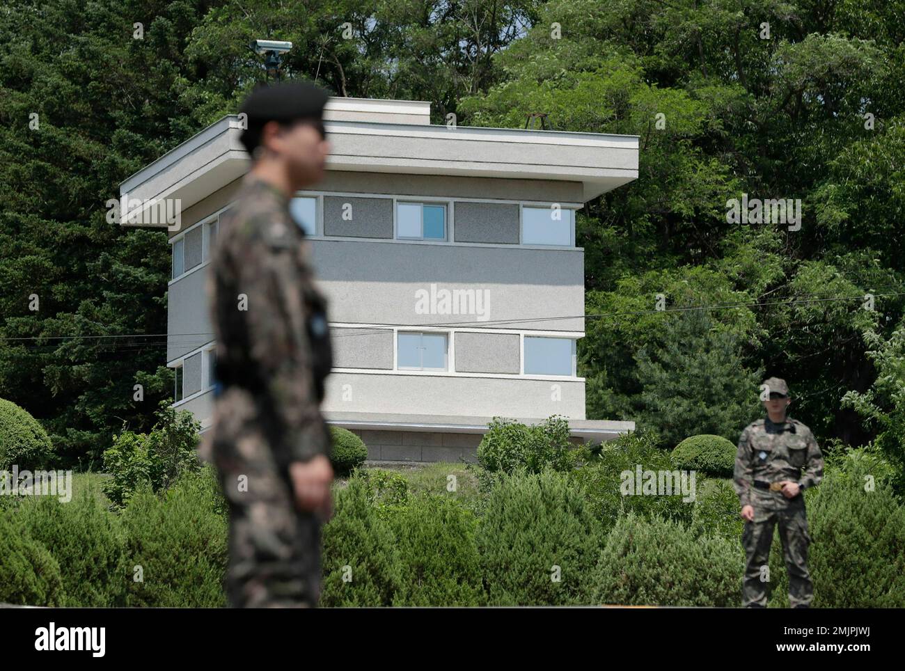South Korean soldiers stand guard as a North Korean guard post, center ...