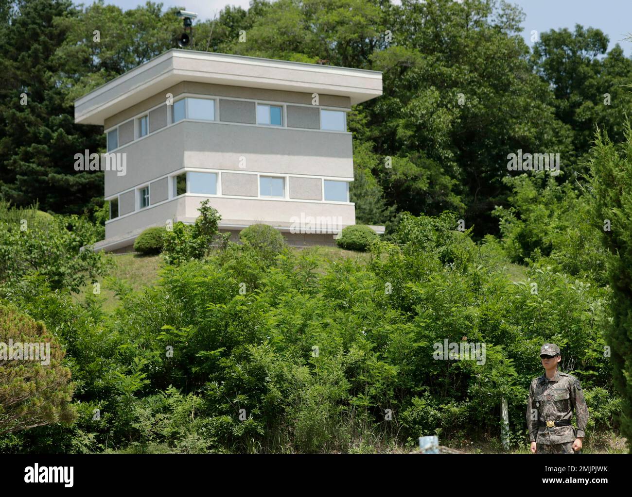 A South Korean soldier stands guard as a North Korean guard post, back ...
