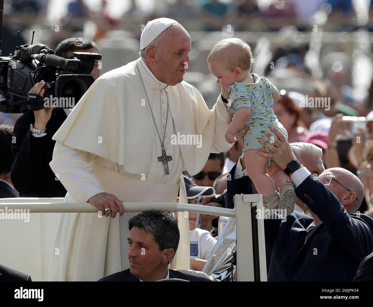 Pope Francis blesses a baby as he arrives for his weekly general ...