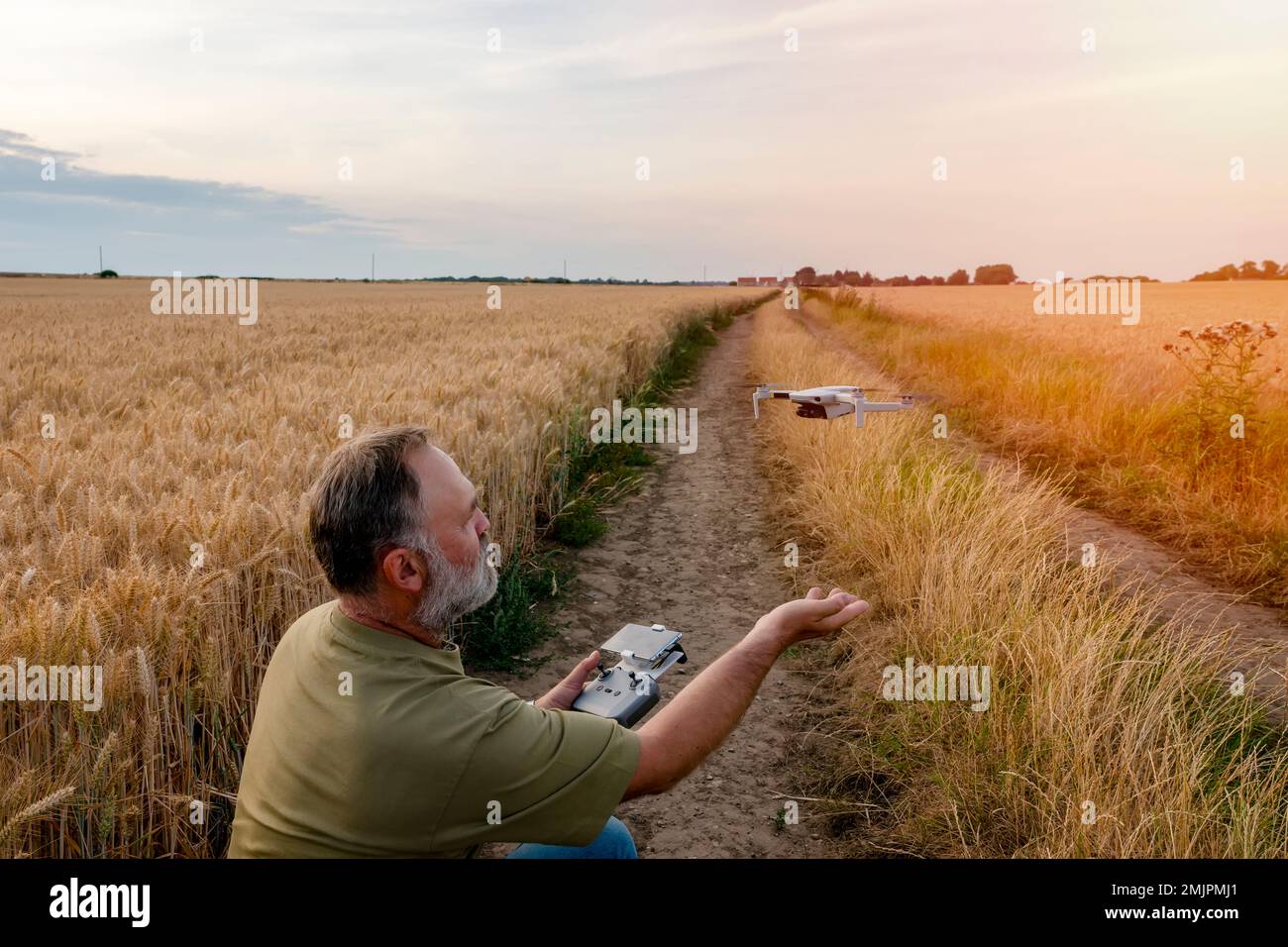 Bearded man using a drone with remote controller making photos and ...