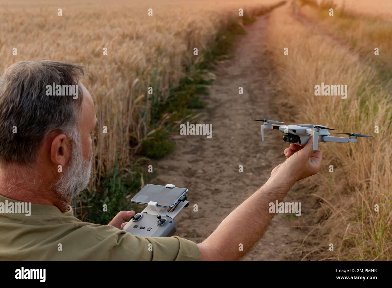 Bearded man using a drone with remote controller making photos and ...