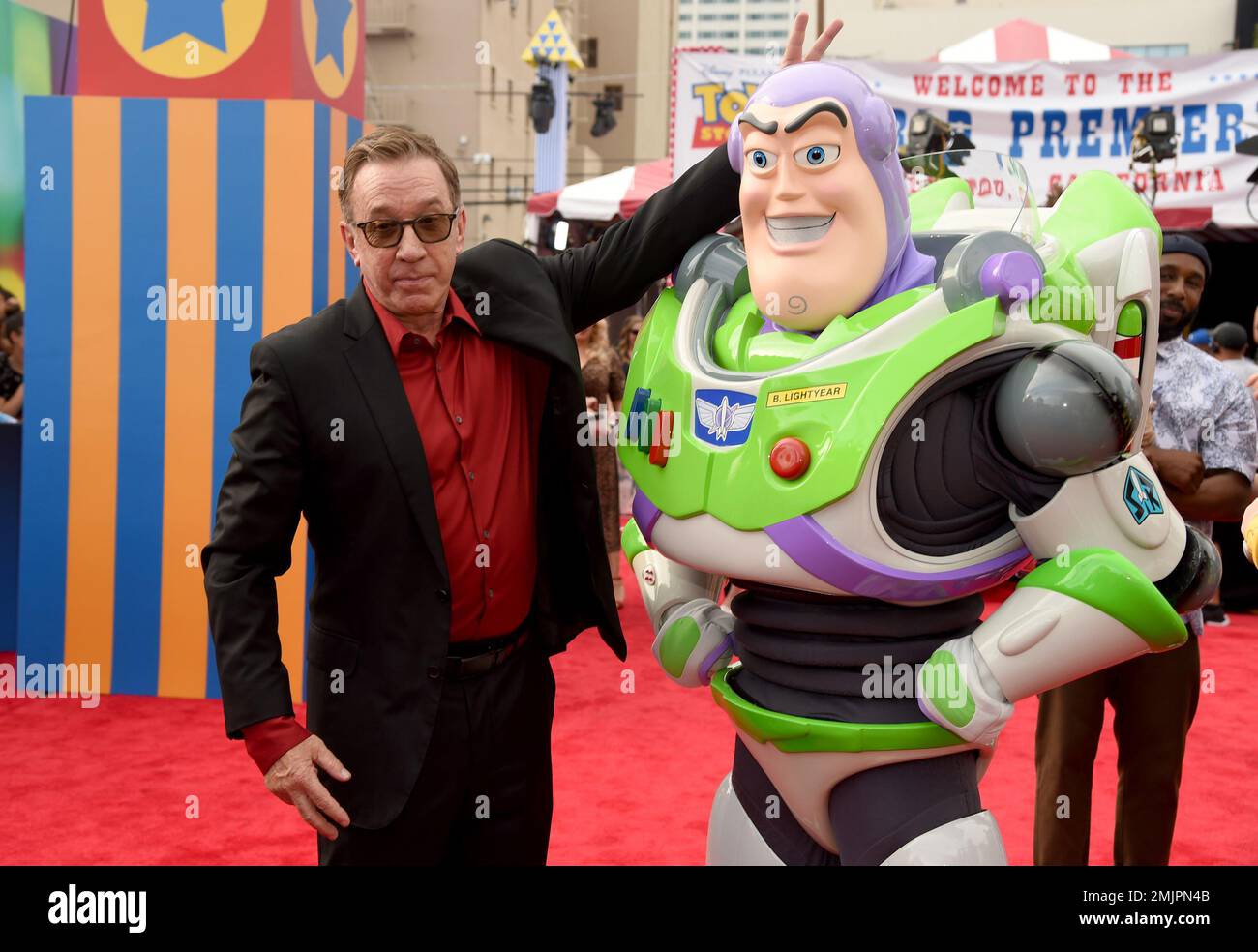 Tim Allen makes rabbit ears behind his character Buzz Lightyear as he ...