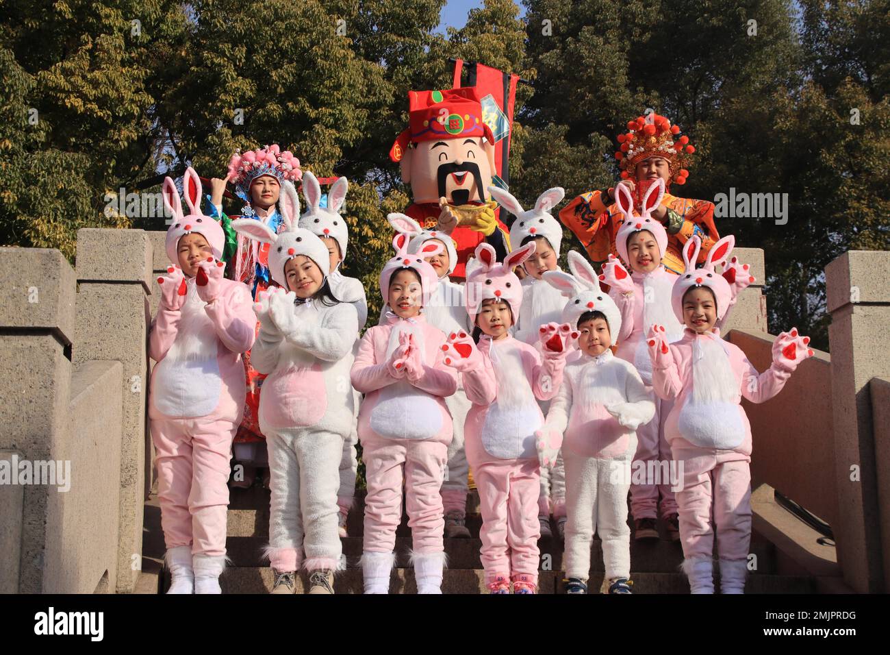 The God of Fortune, or caishen and a group of rabbits acted by children ...