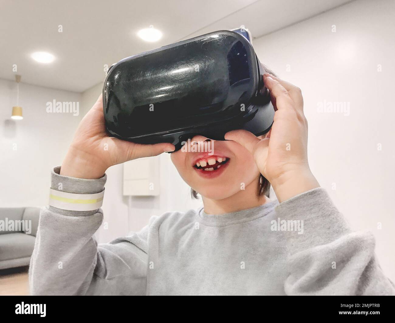 Smiling boy is watching something in VR-glasses. New technology for ...