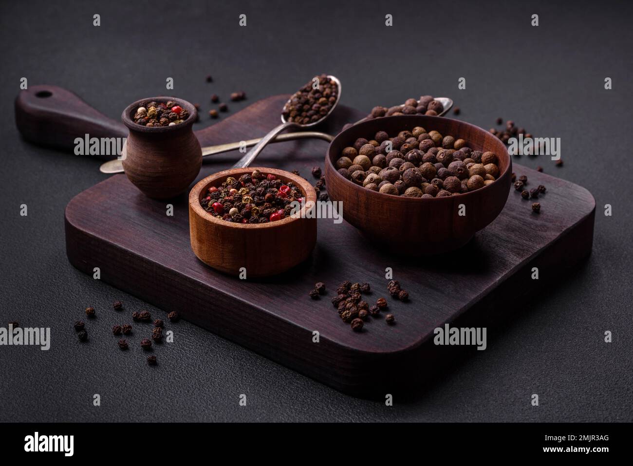 Spice allspice brown color not ground in a wooden saucer on a dark ...