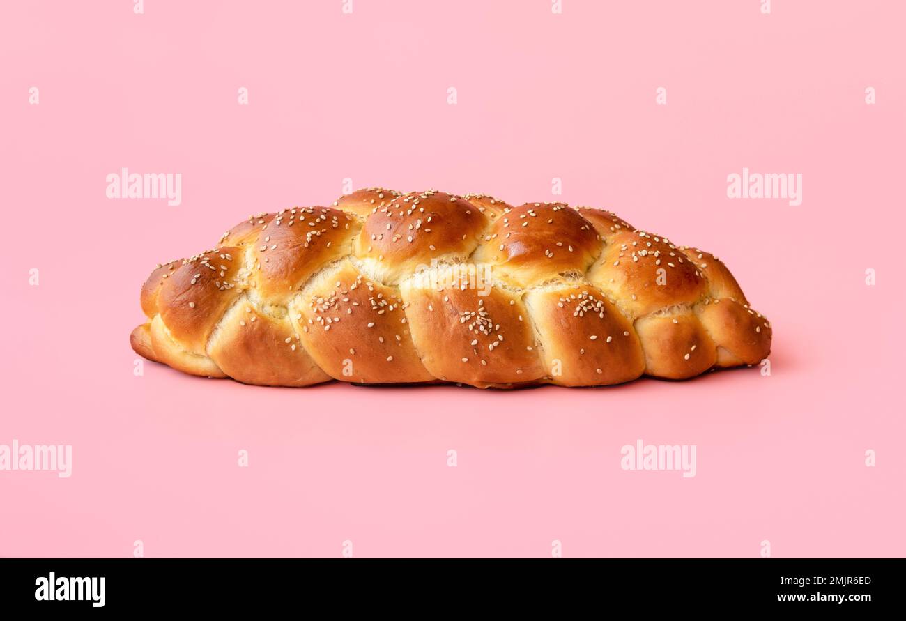 Freshly baked challah bread minimalist on a pink table. Delicious ...