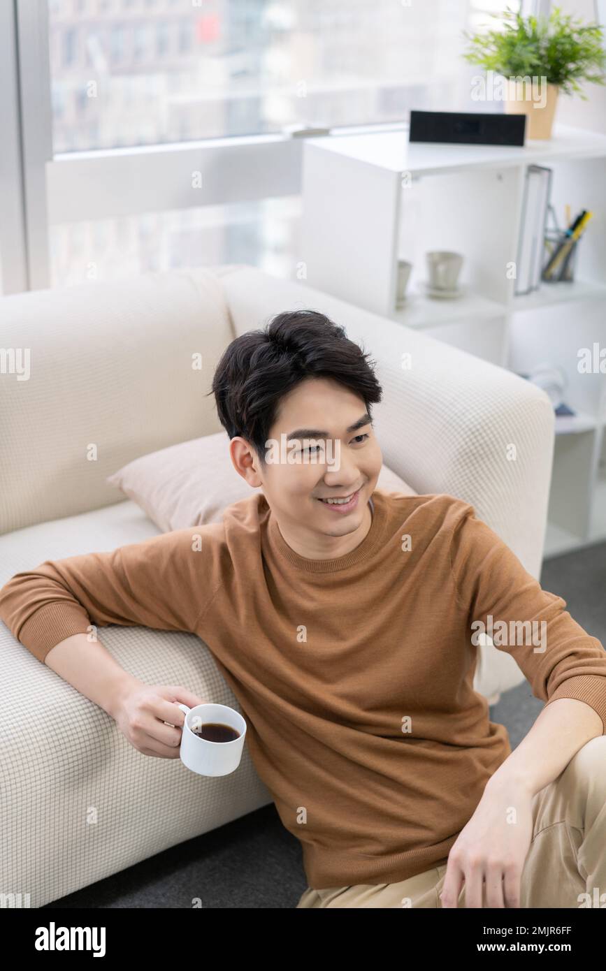 The young man to drink coffee at home Stock Photo - Alamy