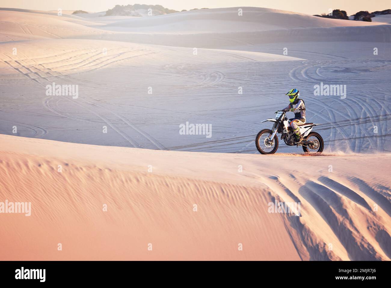 Desert, moto cross and extreme motorbike sport of a man on sand dunes ...