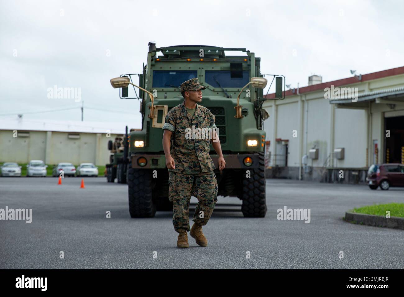 A U.S. Marine ground guides a Medium Tactical Vehicle Replacement with ...