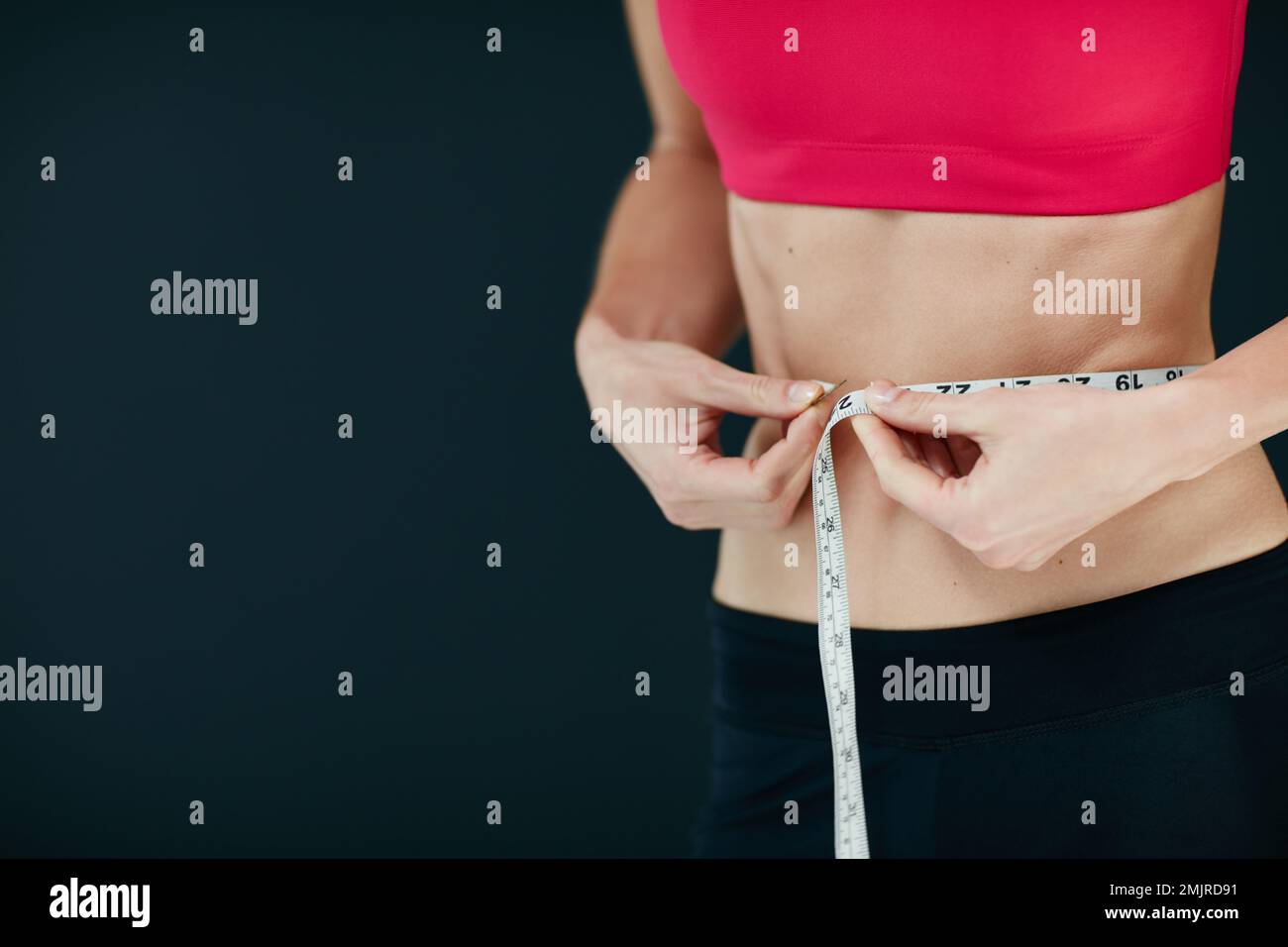 Losing inches. an unrecognizable young woman measuring her waist Stock ...