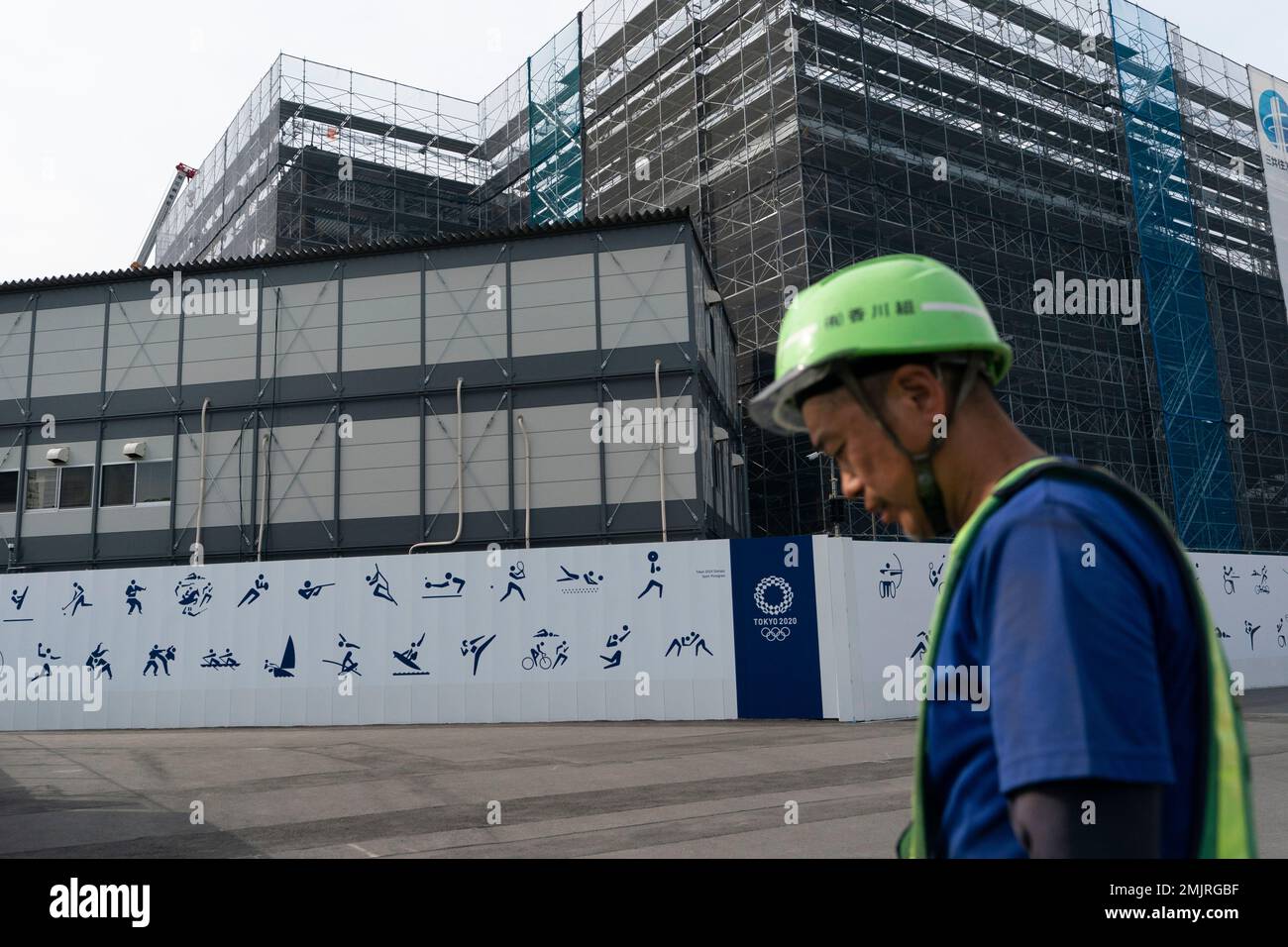 A construction worker walks across the street at the construction site ...