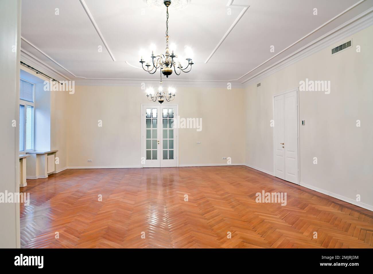 A huge empty room without furniture with laminate flooring and high ...