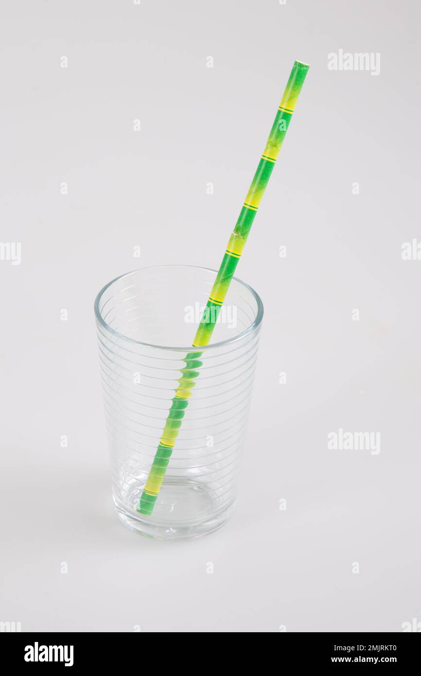 glass transparent empty with green straw in recyclable cardboard on a ...