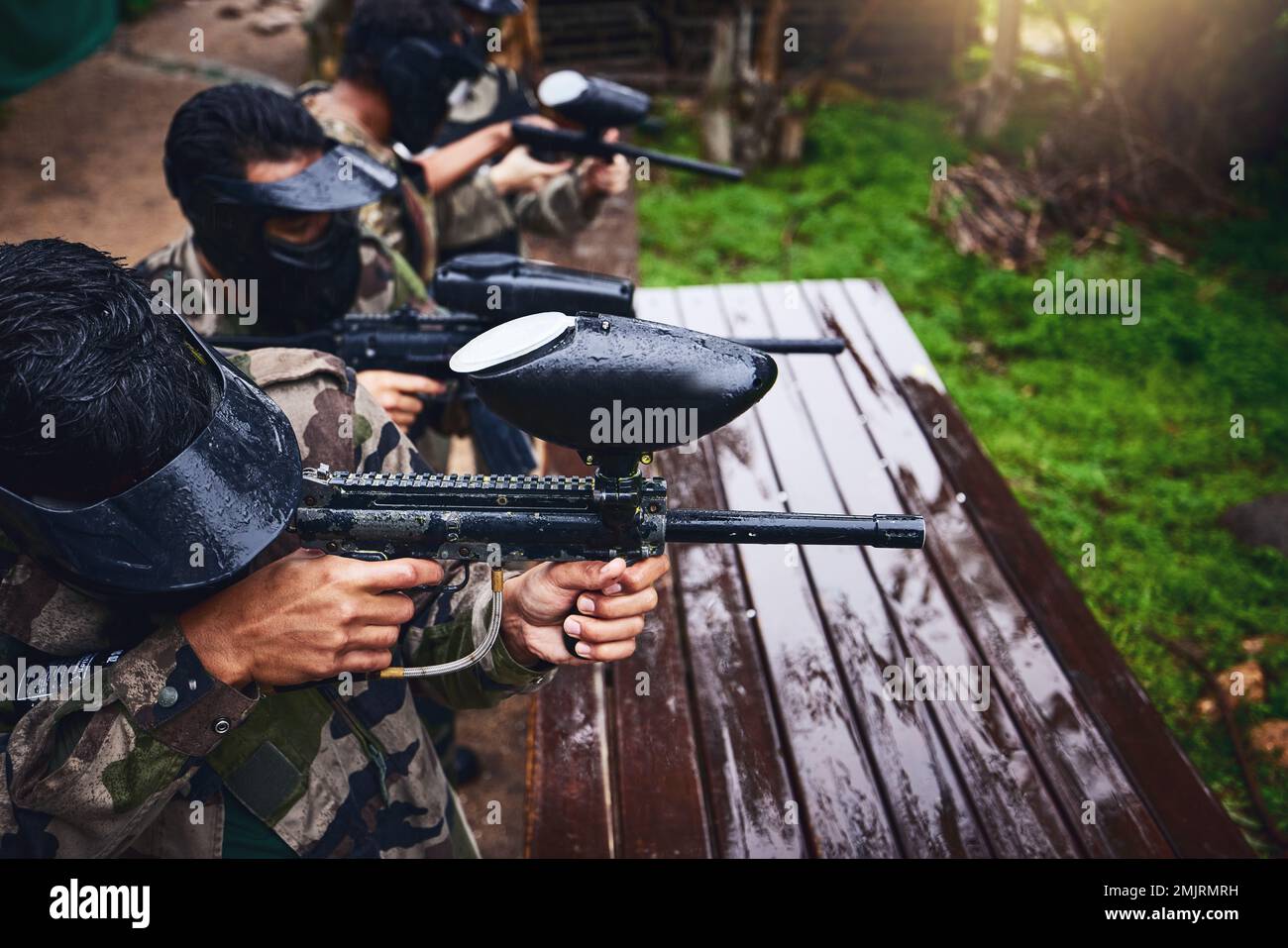Paintball gun, men and games in rain for competition or sports ...