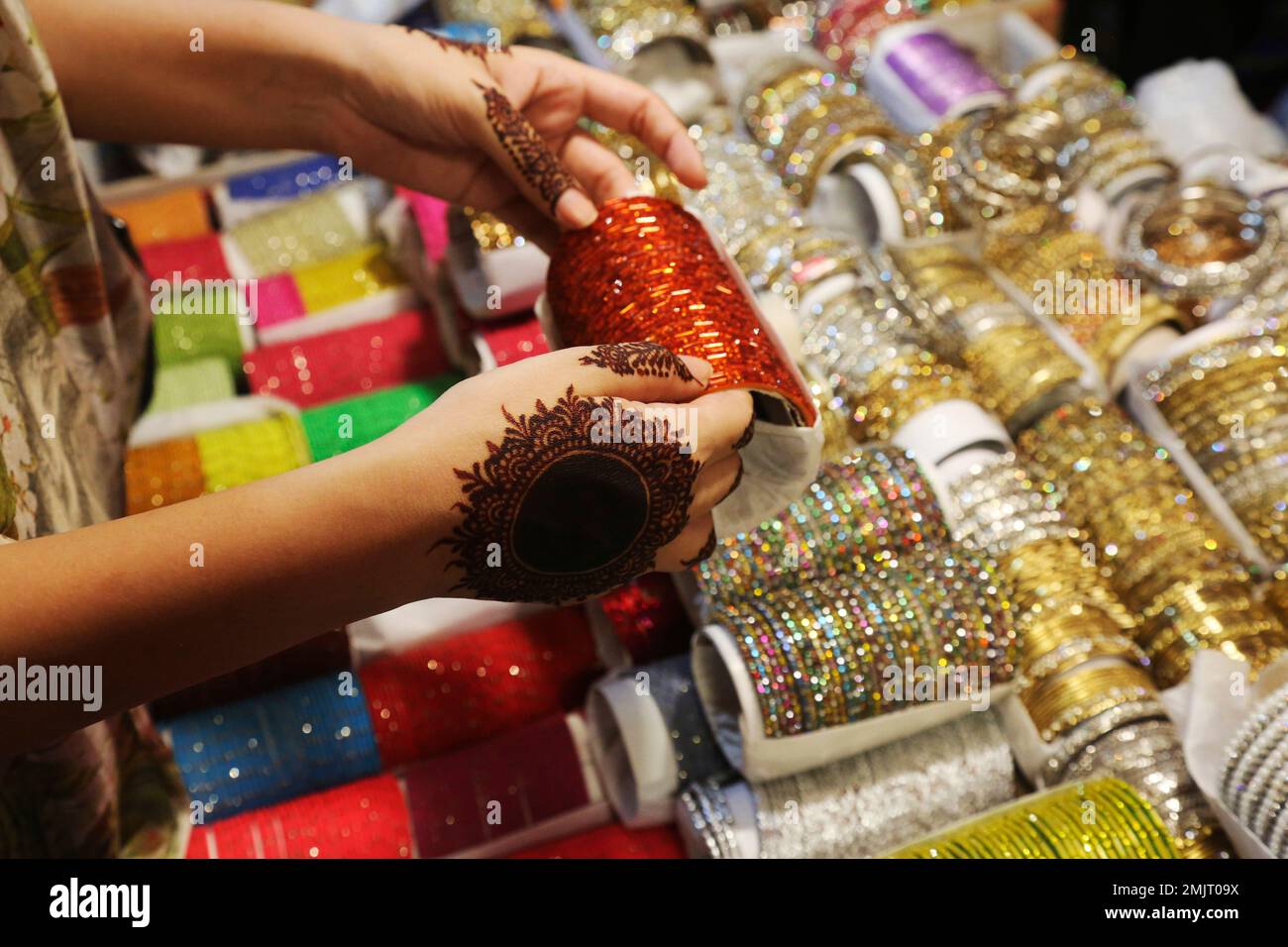 A Muslim girl selects matching bangles in preparation to celebrate the ...