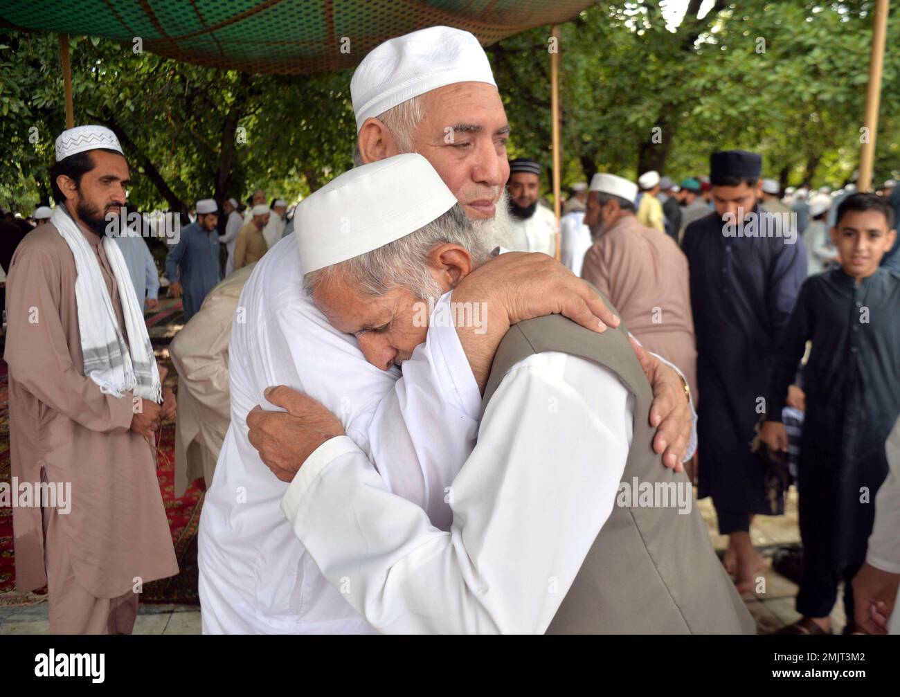 Pakistani Muslims greet each other after offering the Eid al-Fitr ...