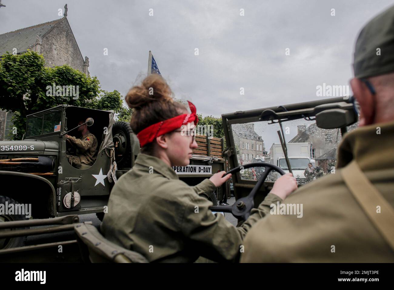A World War II enthusiast drives a period vehicle through a street in ...