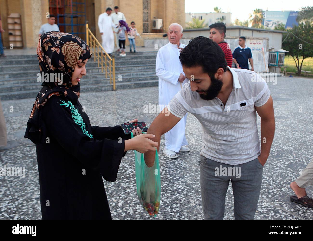 A Muslim woman distributes candies to celebrate Eid al-Fitr after ...