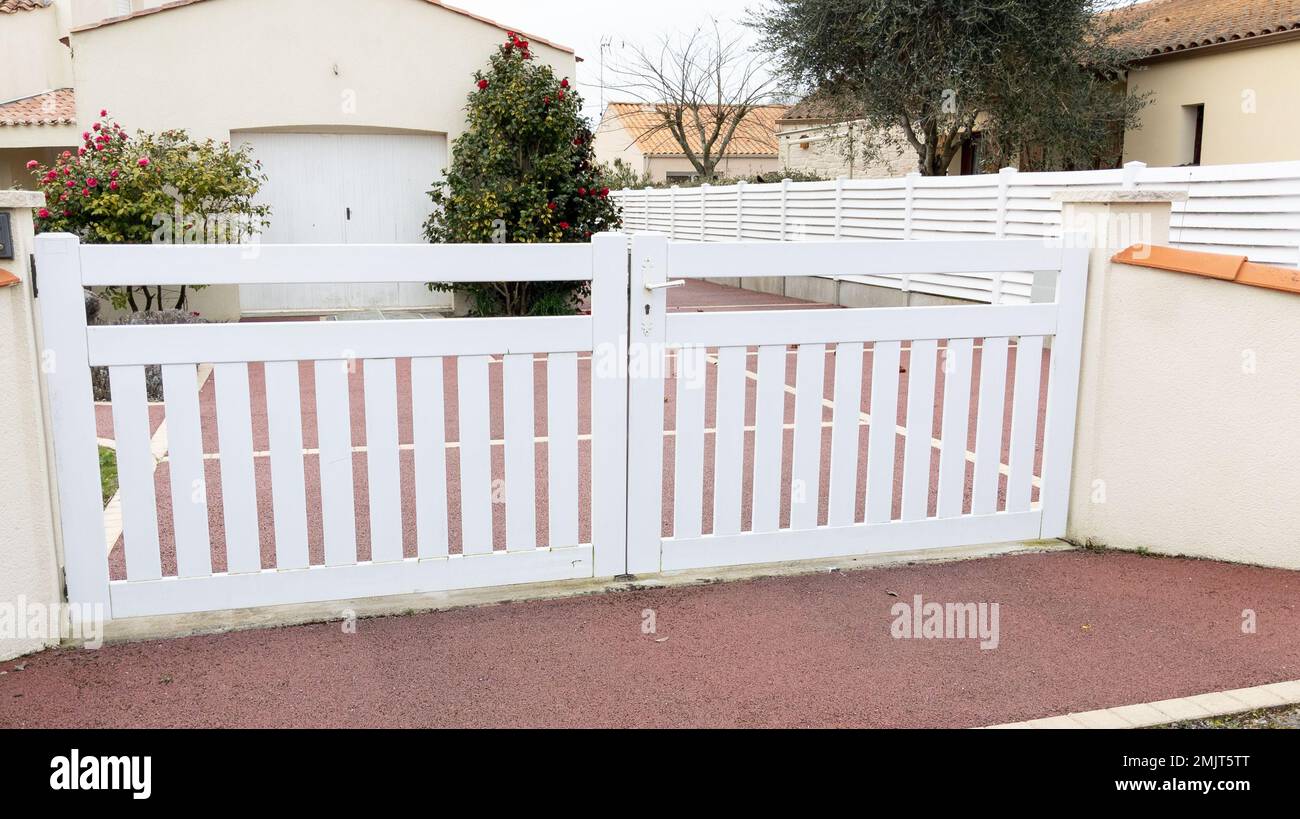 new steel gate white home on suburb street house Stock Photo - Alamy