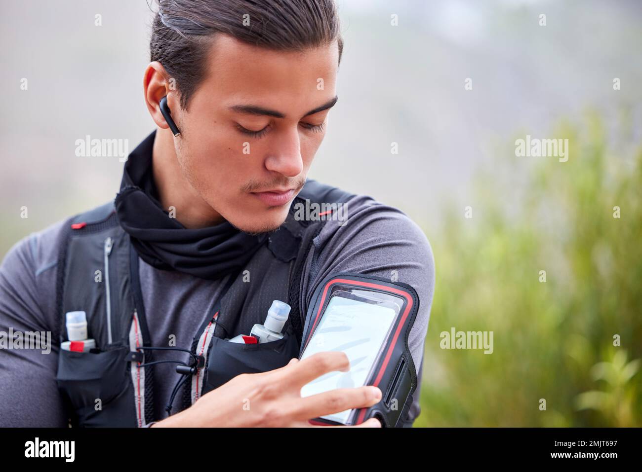 Fitness, phone and man hiking outdoor, trekking in nature with earpods ...