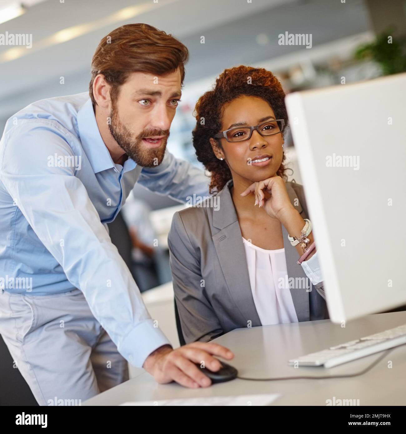 Configuring her computer settings on her first day. two coworkers using ...