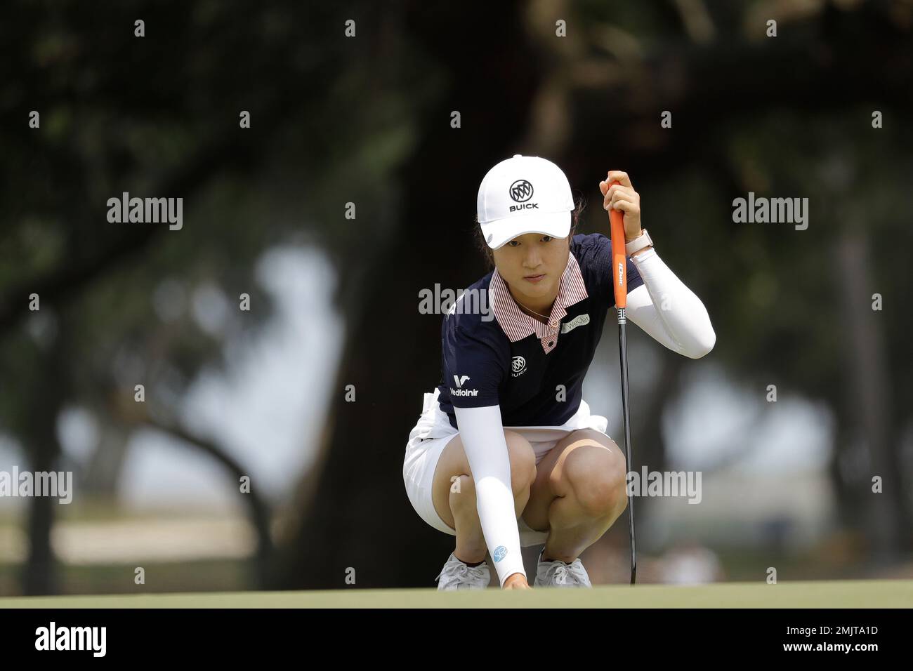 Yu Liu of China, lines up a putt on the first green during the final ...