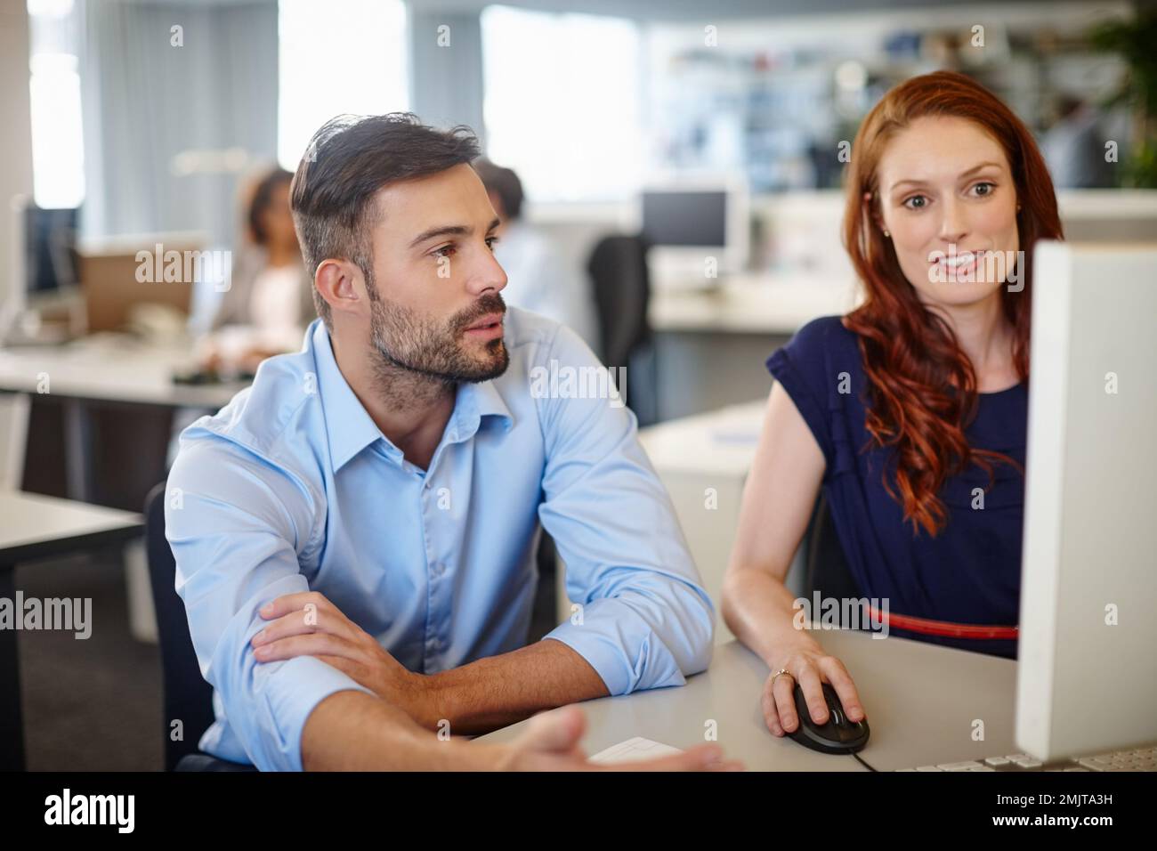 Showing her how to navigate the system. CShot of two coworkers using a ...