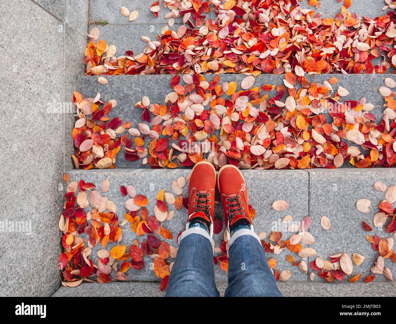 Top view on feet in red leather shoes. Woman is standing on stone ...