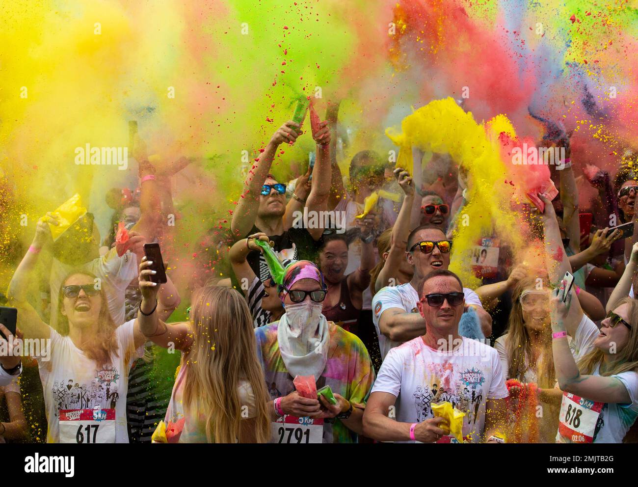 Runners throw powdered paint powder after competing in the 5-kilometer ...