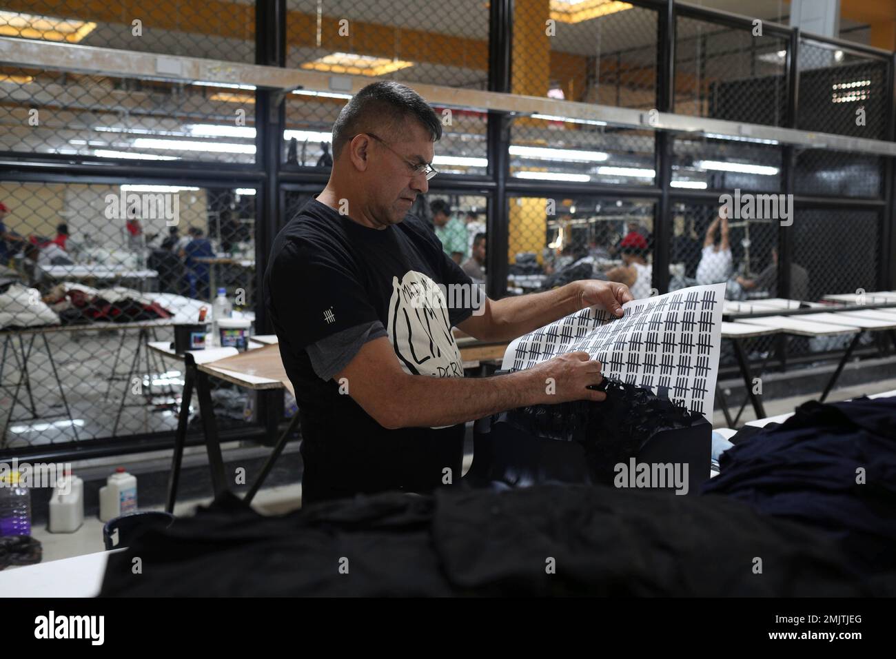 An inmate holds a cloth printed with the Pieta logo that consists of ...