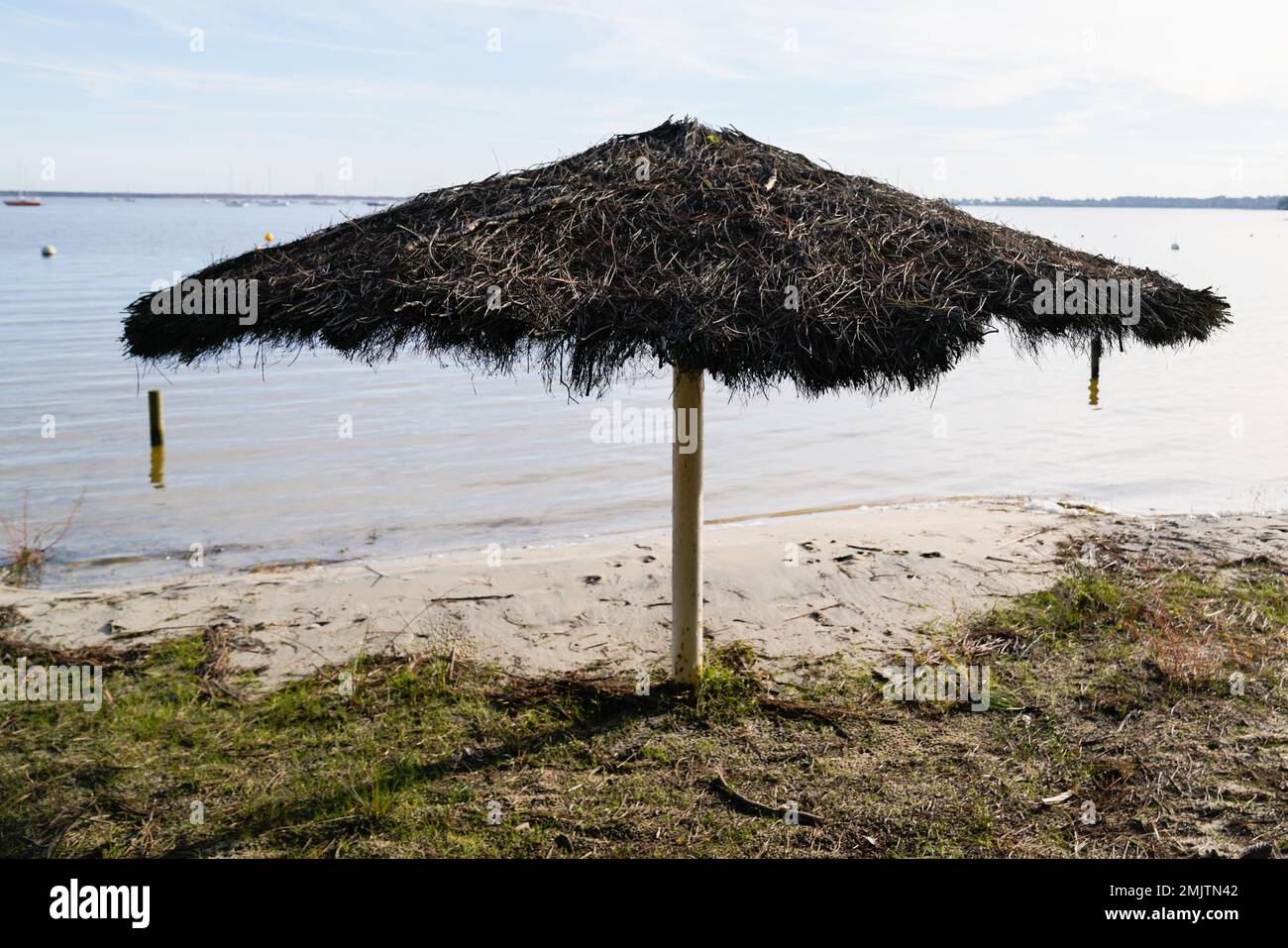 straw parasol in sand lake beach Stock Photo - Alamy